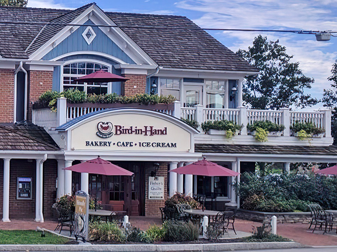 The charming blue and brick exterior of Bird-in-Hand Bakery & Cafe stands like a delicious mirage in Amish Country, complete with inviting porch seating.
