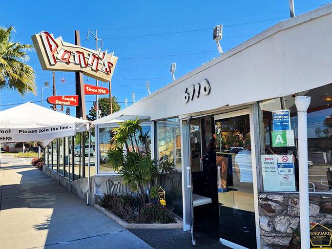 The iconic Pann's sign stands tall against the California sky, a neon beacon promising comfort food that's outlasted countless food trends.