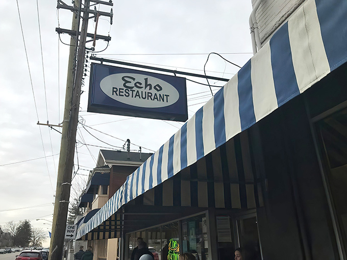The iconic blue and white striped awning of The Echo stands as a beacon of breakfast hope on Hyde Park Square, promising culinary comfort beneath its vintage sign.