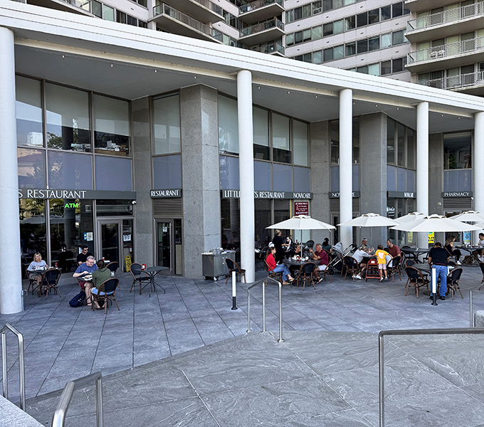 The blue awning of Little Pete's beckons like an old friend, promising comfort food and conversation under those cheerful patio umbrellas.