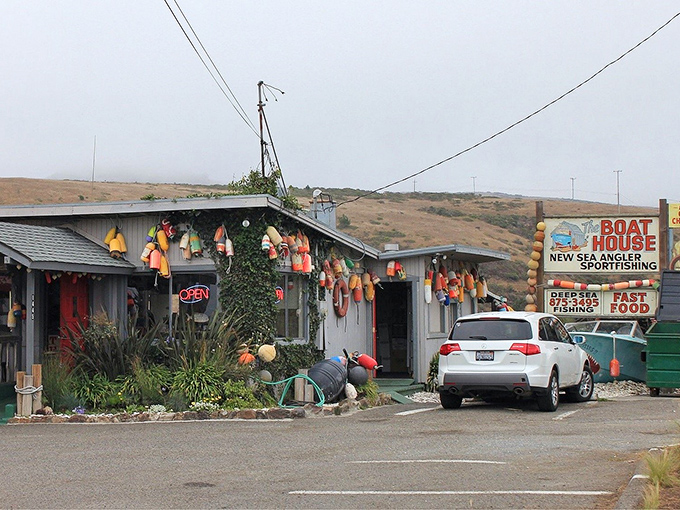 The unassuming exterior of The Boat House, where colorful buoys hang like Christmas ornaments, promising seafood treasures within rather than holiday cheer.
