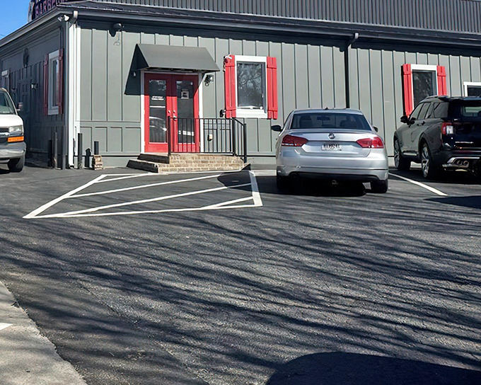 The unassuming gray exterior with punchy red trim is like that quiet friend who suddenly reveals they're a gourmet chef. Barbecue magic happens here.