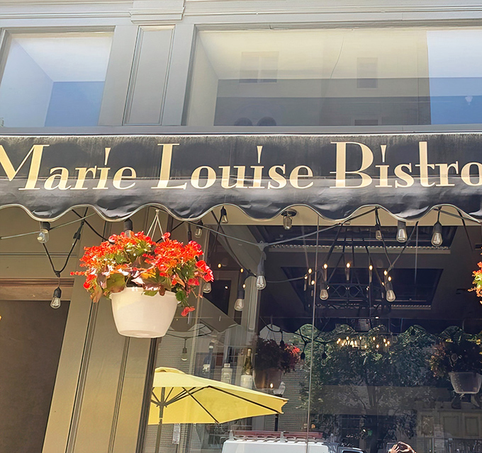 The charming exterior of Marie Louise Bistro glows with warm invitation as evening falls on Baltimore's Mount Vernon neighborhood.