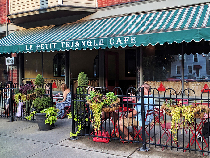 The iconic green and white striped awning of Le Petit Triangle Cafe beckons like a Parisian whisper in Cleveland's Ohio City neighborhood. Sidewalk dining never looked so inviting.