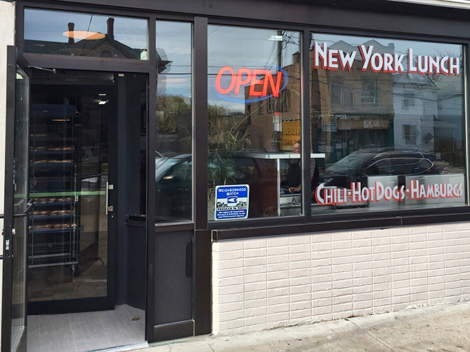 The unassuming storefront of New York Lunch beckons with neon promises of chili, hot dogs, and hamburgs&mdash;culinary poetry in simplicity.