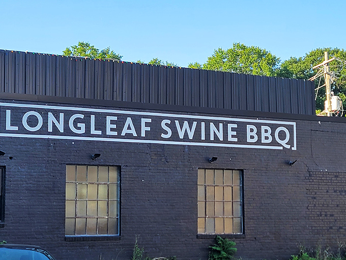The sleek black brick exterior of Longleaf Swine announces itself with understated confidence, like a barbecue joint that knows it doesn't need to shout.
