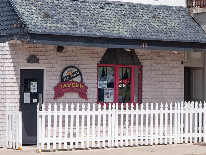The unassuming brick exterior of The View Tavern, with its charming red trim and white picket fence, proves great food often hides in plain sight.