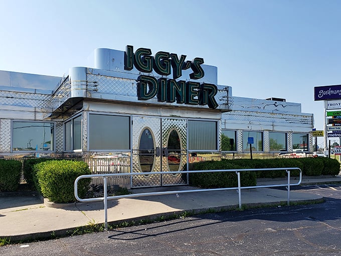 The gleaming metallic exterior of Iggy's Diner shines like a chrome beacon on Route 66, promising nostalgic comfort and culinary treasures within.