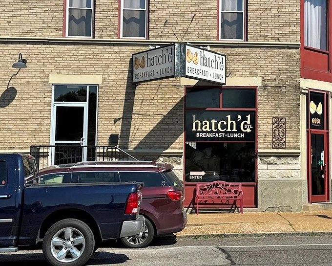 The charming brick exterior of hatch'd STL beckons hungry St. Louis locals with its vintage signage and welcoming red bench—breakfast paradise found!