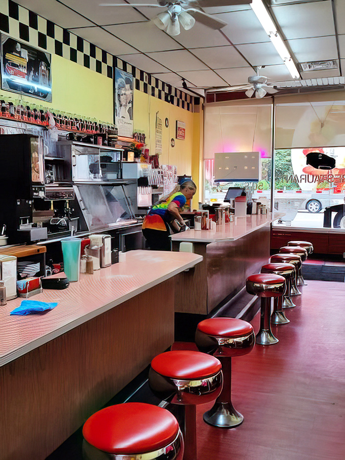 The classic diner counter setup where every seat offers front-row tickets to the culinary show.