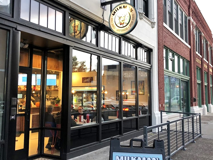 Milkman's sleek storefront beckons like a modern-day burger beacon, promising delicious treasures behind those gleaming black-framed windows.