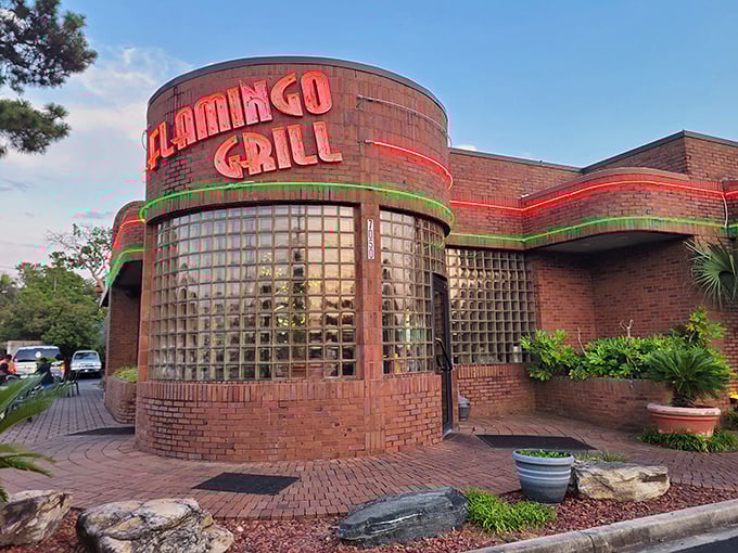 The iconic neon-lit exterior of Flamingo Grill stands as a beacon of culinary promise, its distinctive glass block windows and brick fa&ccedil;ade hinting at the retro elegance within.