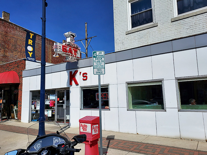 The unassuming white exterior of K's Hamburger Shop in Troy stands as a time capsule of Americana, complete with that classic neon sign that's been beckoning hungry travelers for generations.