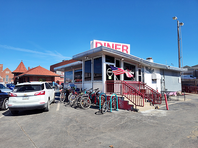 The classic red and white exterior of Broadway Diner stands like a time capsule of Americana, complete with that iconic neon sign beckoning hungry travelers.