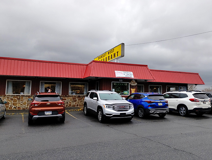 The bright yellow sign and classic red roof of Sunset West Restaurant stand as beacons of hope for hungry travelers on Pennsylvania's winding roads.