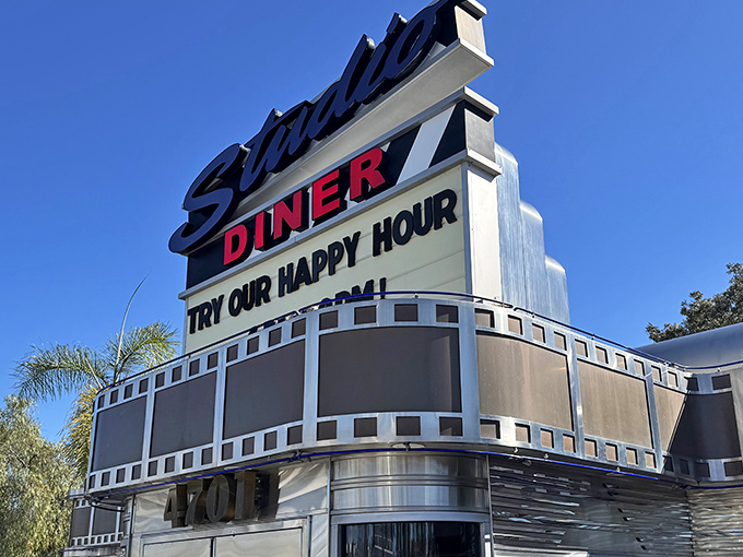 The iconic Studio Diner sign stands tall against the San Diego sky, promising cinematic cuisine and happy hour delights in a film-inspired setting.
