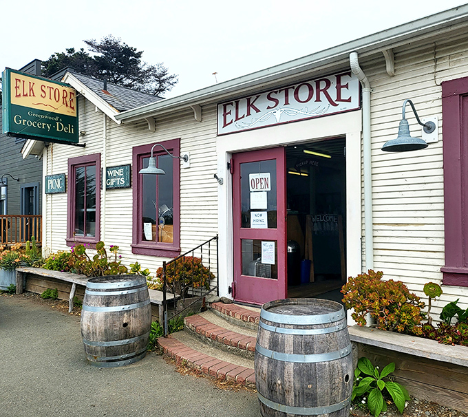 The quintessential coastal discovery: Elk Store's charming white clapboard exterior with burgundy trim and wooden barrels promises treasures that chain stores can't deliver.