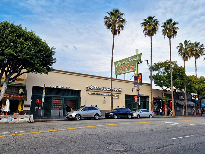 The iconic green and white sign of Musso & Frank Grill stands proudly on Hollywood Boulevard, a beacon of culinary history amid the tourist attractions.