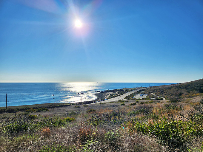 The California coastline stretches out like nature's own infinity pool. This panoramic view of Leo Carrillo State Park captures the meeting of rugged hills and sparkling Pacific waters.