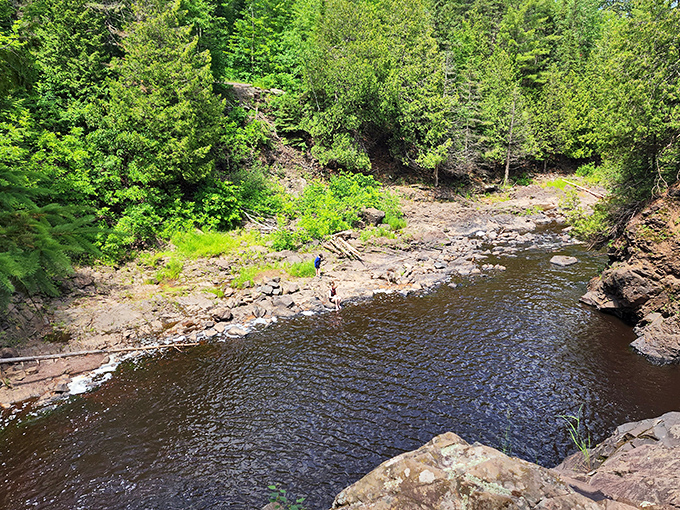 The Black River carves its ancient path through billion-year-old volcanic rock, creating a serene swimming hole that beckons on hot summer days.