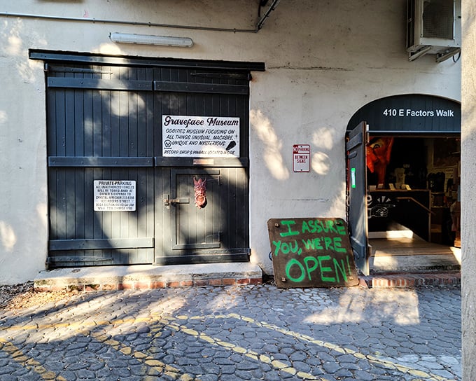 The unassuming entrance to Savannah's strangest attraction. That handwritten "I assure you, we're OPEN" sign is both an invitation and a dare.