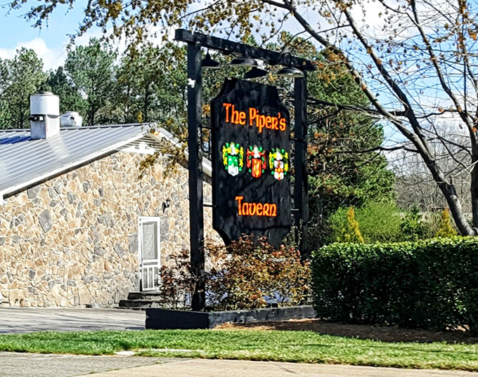 The stone facade and distinctive sign of The Piper's Tavern stands like a culinary fortress, promising British comfort in the heart of North Carolina.