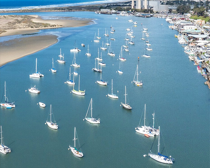 Morro Bay's iconic rock stands sentinel over a harbor dotted with sailboats, like nature's own lighthouse guiding travelers to this coastal haven.