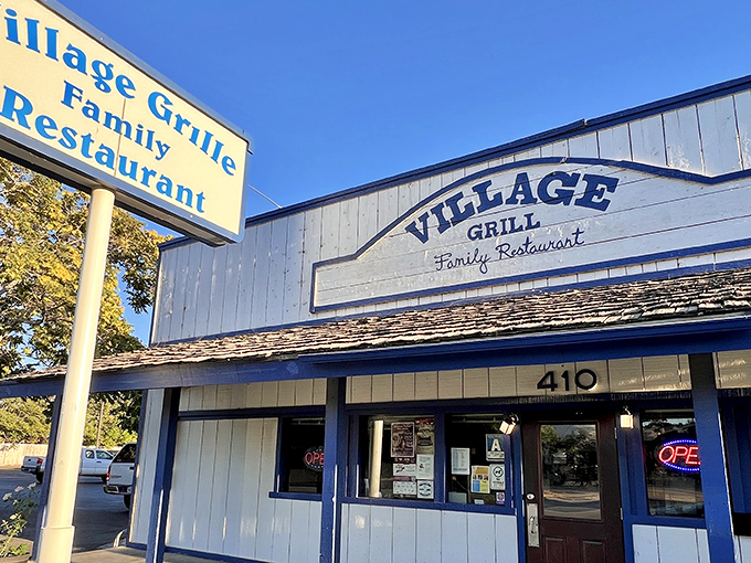 The blue-trimmed facade of Village Grill stands like a beacon of breakfast hope on Tehachapi Boulevard, promising comfort food salvation to hungry travelers.