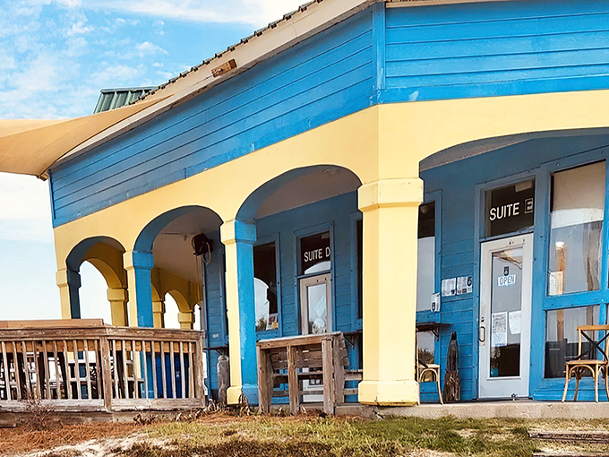 The cheerful blue and yellow exterior of Blue Mountain Bakery stands out like a tropical oasis against Florida's coastal landscape.
