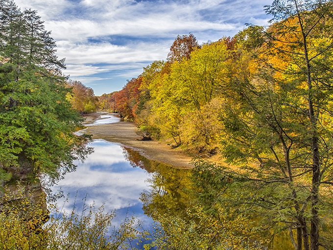 Sugar Creek's mirror-like surface perfectly captures autumn's fiery palette, creating a double dose of Indiana splendor that would make Bob Ross reach for his happy little brushes.