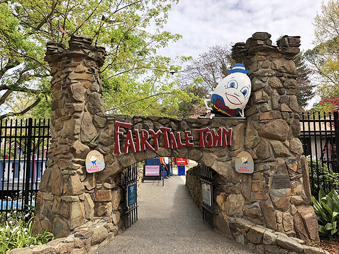 The iconic entrance to Fairytale Town beckons with its whimsical clock tower and Humpty Dumpty perched precariously atop the stone wall. 
