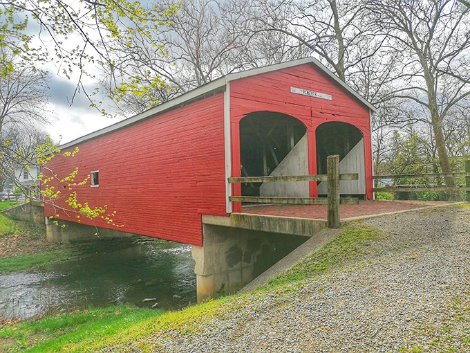The crimson sentinel of Seven Mile Creek stands proudly against the Ohio sky, its vibrant red siding a beacon to history buffs and romantics alike.