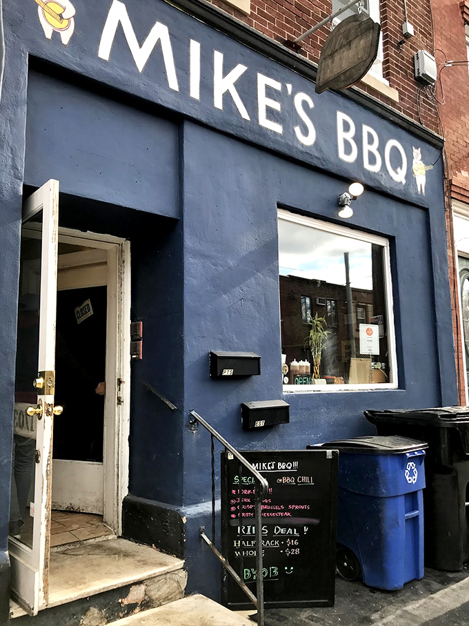 The blue storefront of Mike's BBQ stands out like a beacon of smoky hope on South Philly's 11th Street, complete with an adorable pig logo that practically winks at you.