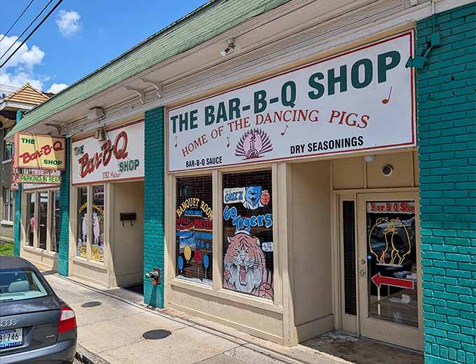 The iconic green storefront of The Bar-B-Q Shop proudly declares itself "Home of the Dancing Pigs," a promise of barbecue magic that awaits inside.