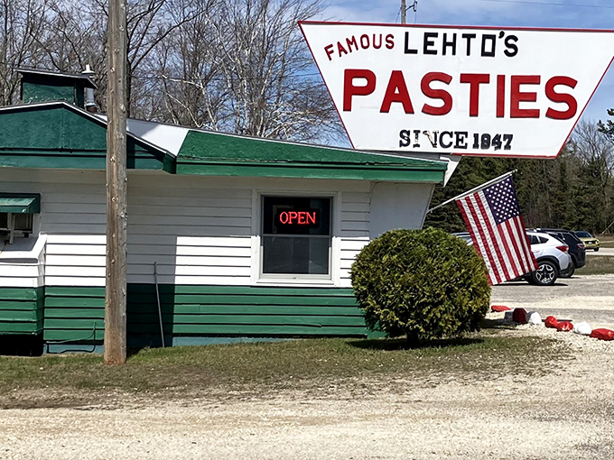 The unassuming exterior of Lehto's Pasties stands like a culinary lighthouse on US-2, beckoning hungry travelers with its iconic triangular sign since 1947.