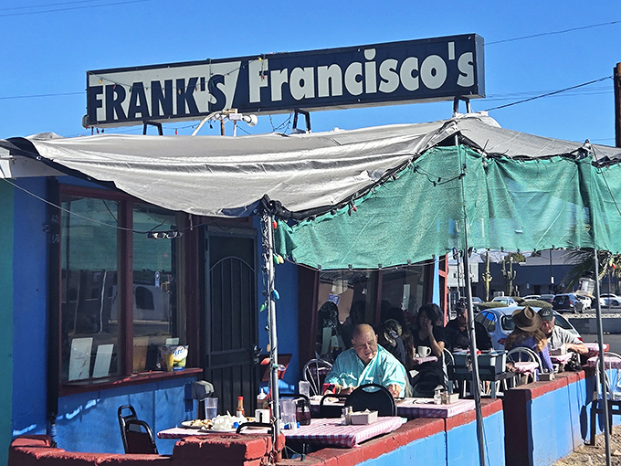 The unassuming blue exterior of Frank's Restaurant, where the sign promises good food and the patio delivers on Tucson's perfect weather.