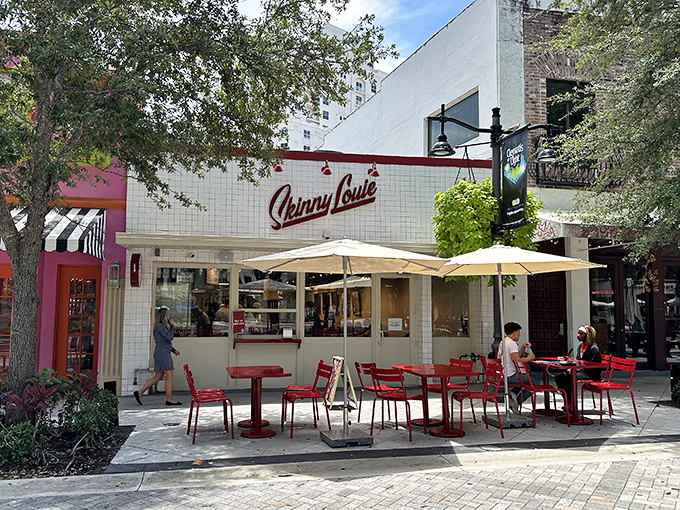 The iconic white-tiled fa&ccedil;ade with bold red "Skinny Louie" script stands like a beacon of burger hope in Miami's bustling landscape.