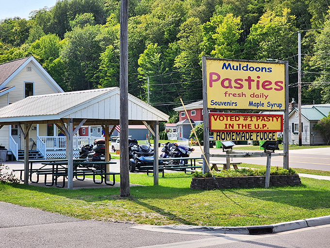 The iconic yellow sign of Muldoons stands proud in Munising, promising pasty perfection and homemade fudge to hungry travelers exploring Michigan's Upper Peninsula.