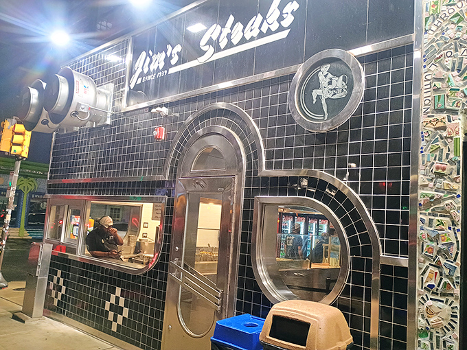 The iconic black-tiled facade of Jim's South St. gleams like a cheesesteak beacon on Philadelphia's famous street, promising delicious adventures within.