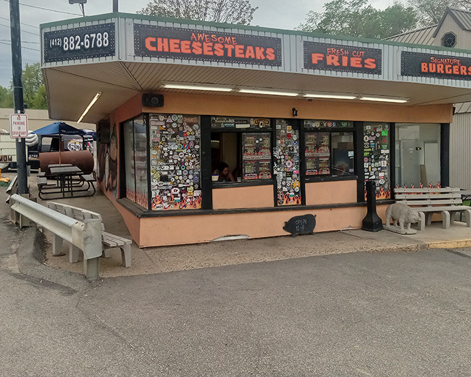 The unassuming peach-colored exterior of Rowdy BBQ, where sticker-covered windows hint at the cult following inside. Barbecue paradise rarely comes with fancy facades.