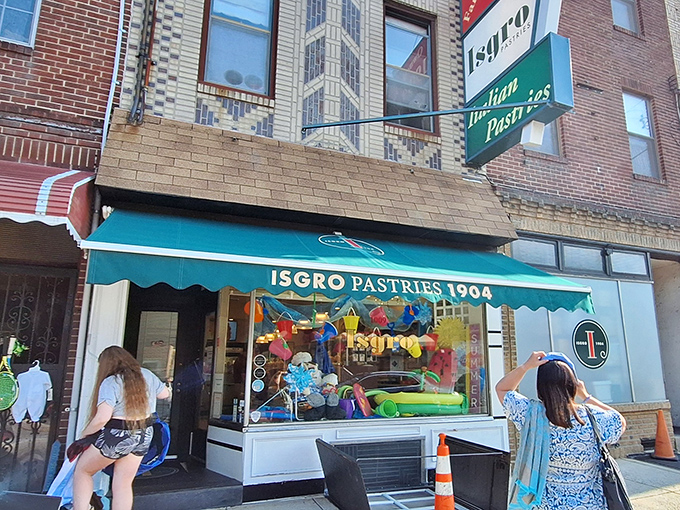 The teal awning of Isgro Pastries has been a beacon of sweetness in South Philly since 1904. Some architectural trends come and go, but cannoli is forever.