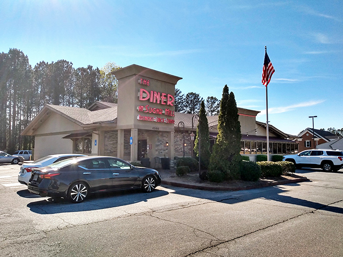 The classic stone facade and iconic red sign of The Diner at Sugar Hill promise comfort food paradise beneath the Georgia sky.