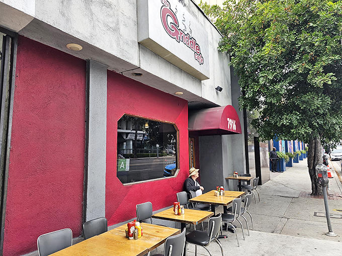 The vibrant red facade of The Griddle Cafe stands out on Sunset Boulevard like a beacon for breakfast enthusiasts. Simple outdoor seating belies the culinary magic happening inside.