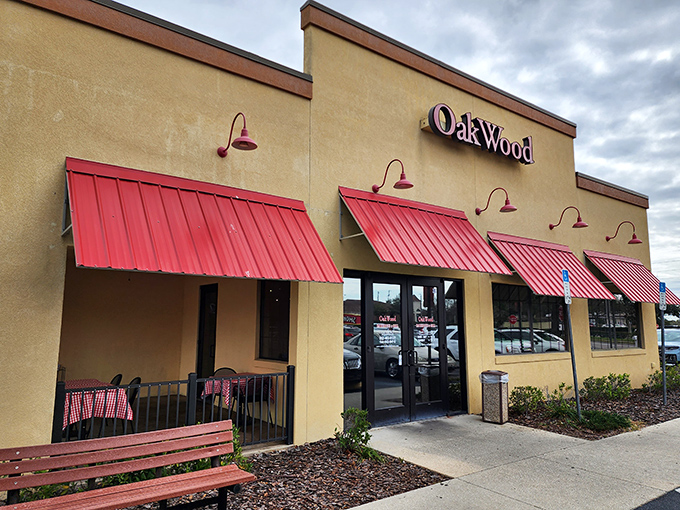 The welcoming tan exterior with bright red awnings promises what every BBQ pilgrim seeks &ndash; authentic flavor without pretension.