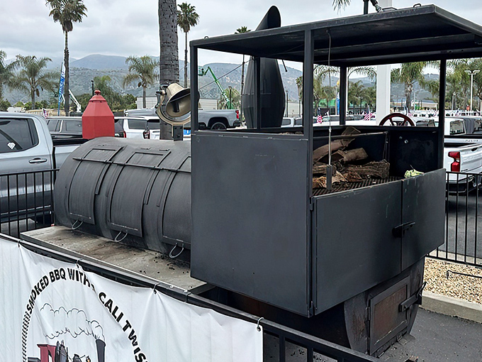 The heart of barbecue magic: R+Q's impressive smoker stands ready to transform ordinary meat into extraordinary memories under California's palm-lined skies.