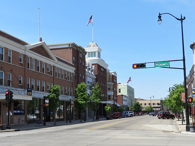 Downtown Beloit's historic architecture stands proudly along Pleasant Street, where brick buildings house local businesses beneath a perfect Midwestern sky.