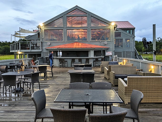 Sunset magic meets architectural brilliance at Old Oyster Factory's waterfront deck, where cocktails and conversation flow as freely as the marsh breeze.