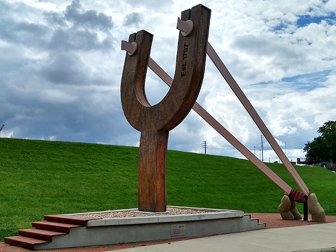 The iconic wooden frame of The Slingshot stands tall against Columbus' urban backdrop, a playful monument to childhood nostalgia supersized for adult appreciation.