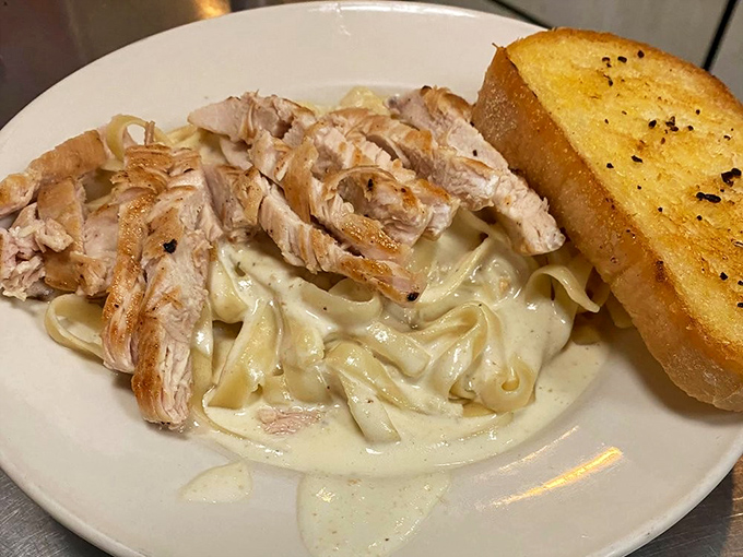 Pasta Alfredo with grilled chicken and garlic bread that would make an Italian grandmother nod in approval while secretly asking for the recipe.