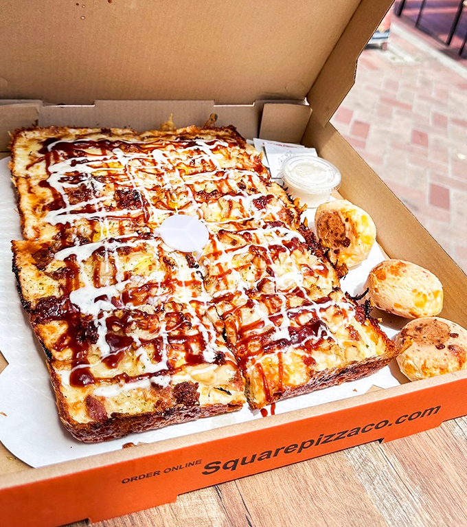 BBQ sauce latticed across the top like edible architecture. Those golden dough balls on the side? The unsung heroes of this pizza experience.